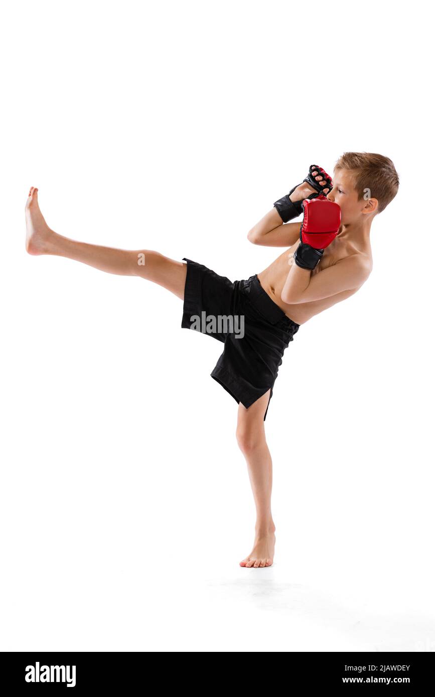 Beginner athlete, kid in sports shots and gloves practicing thai boxing ...