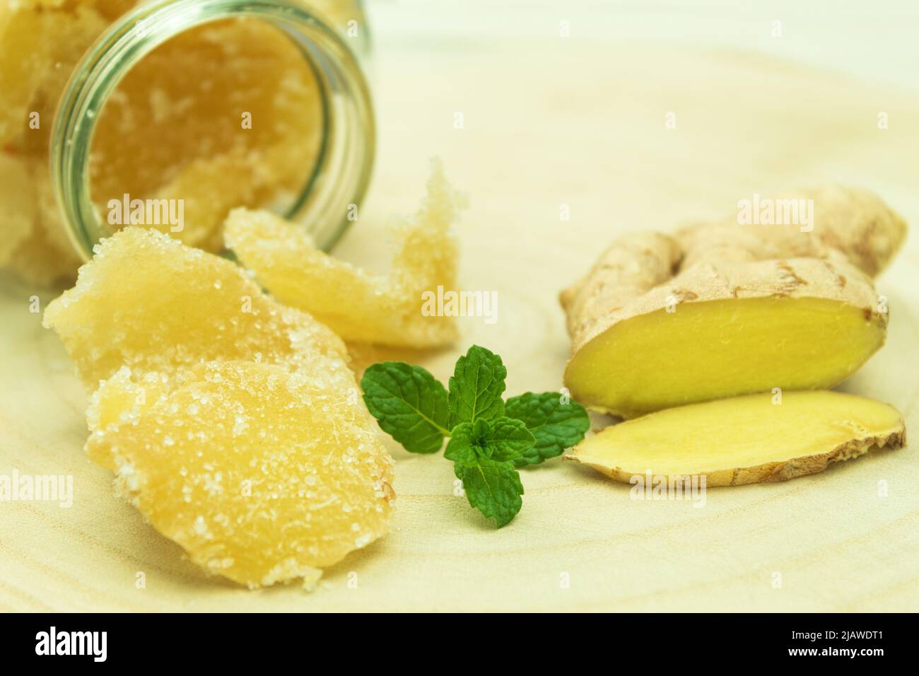 Fresh ginger root and candied ginger in sugar. Close-up of candied ...