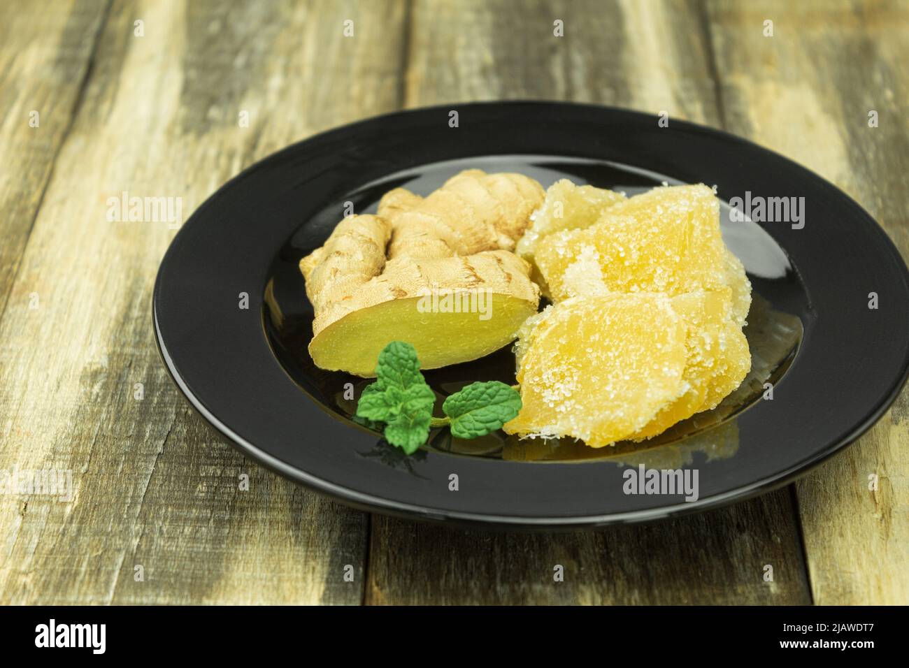 Fresh ginger root and candied ginger in sugar. Close-up of candied ...