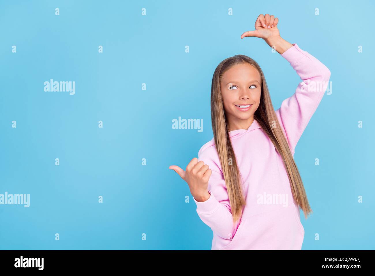 Photo of dreamy cool happy positive small girl point finger thumb empty ...
