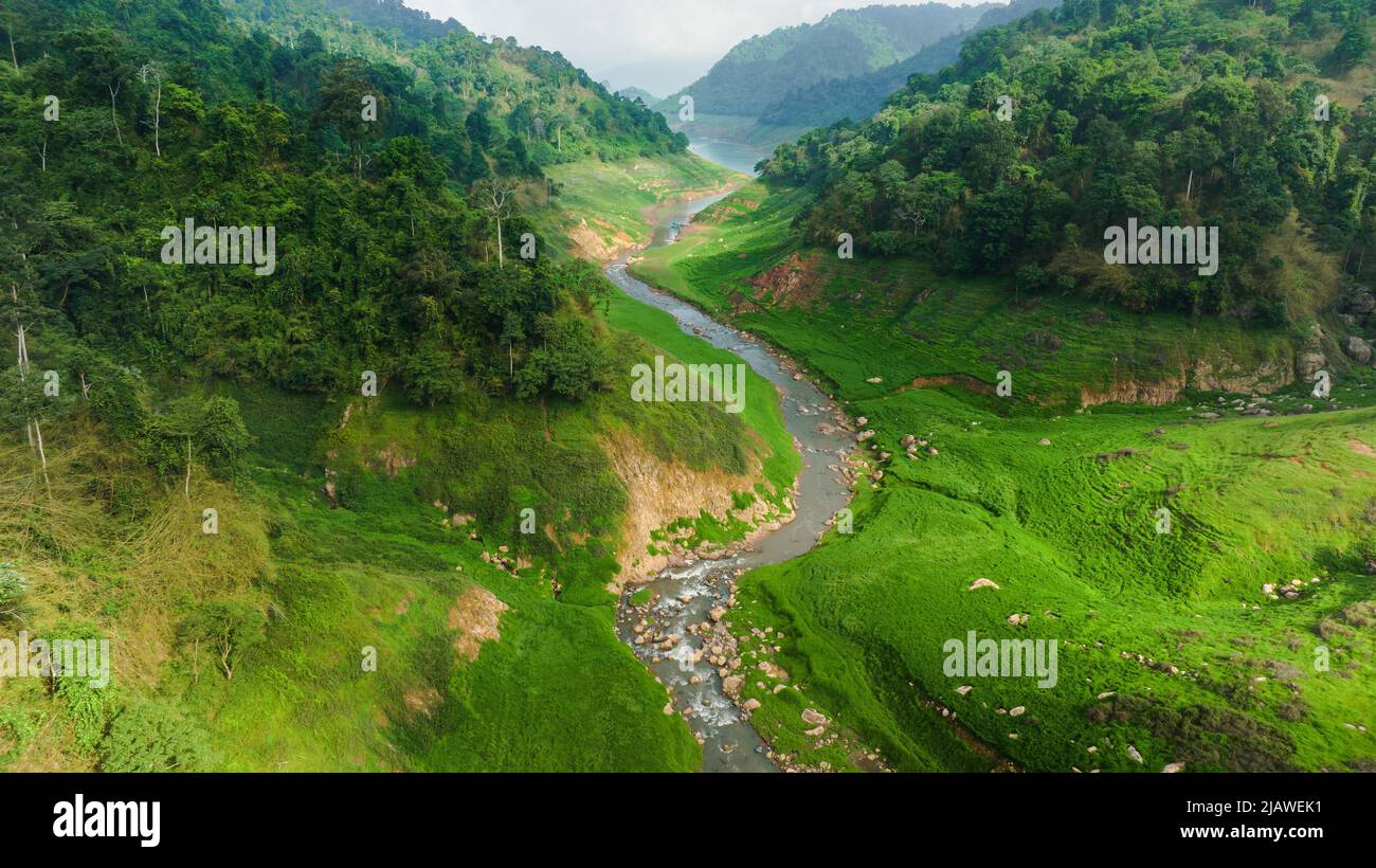 Aerial view of beautiful natural water stream and green field of grass ...