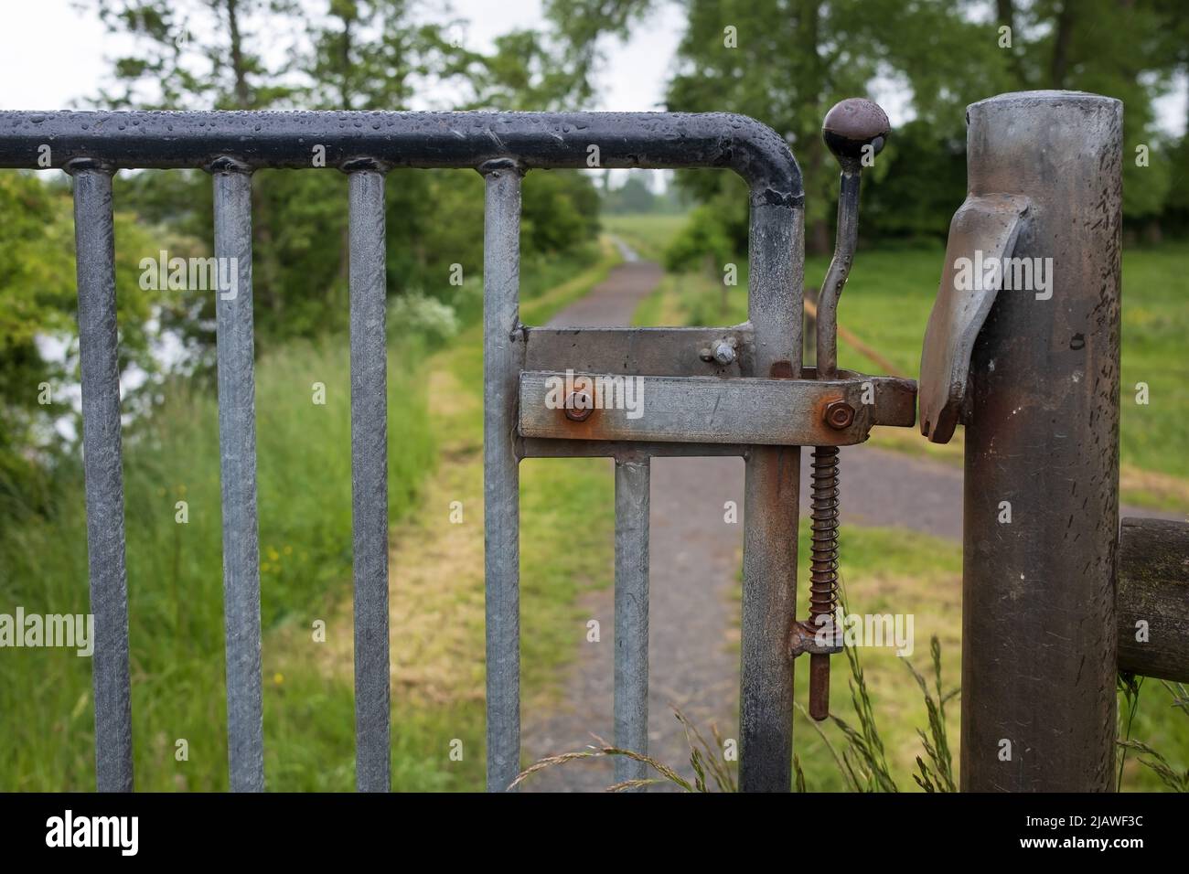 Metal gate with a latch, limiting the passage to the fenced area ...