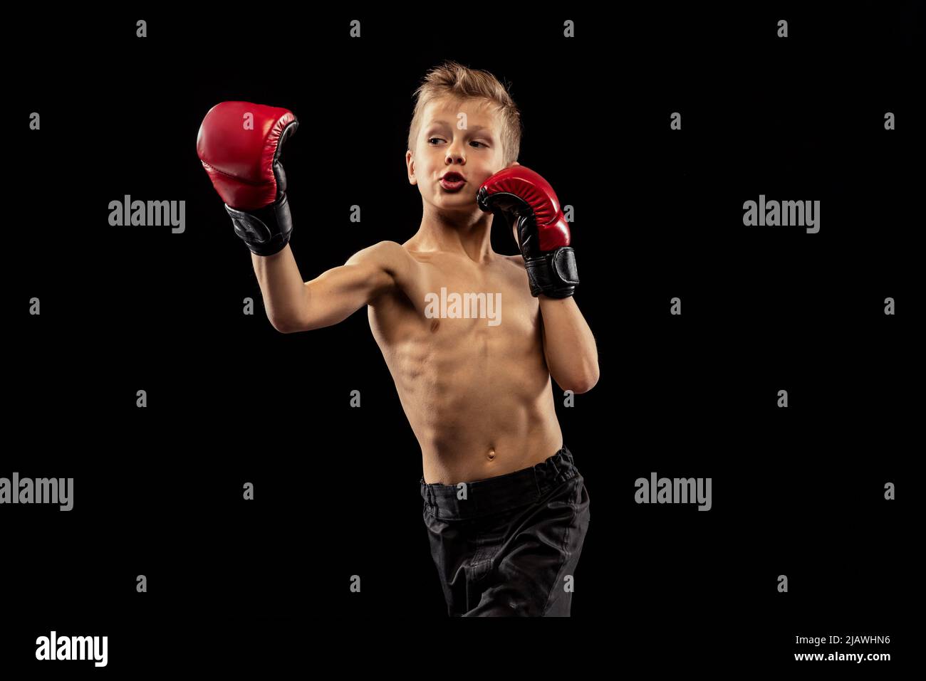 Studio shot of preschool boy, cute kid in sports shots and gloves ...