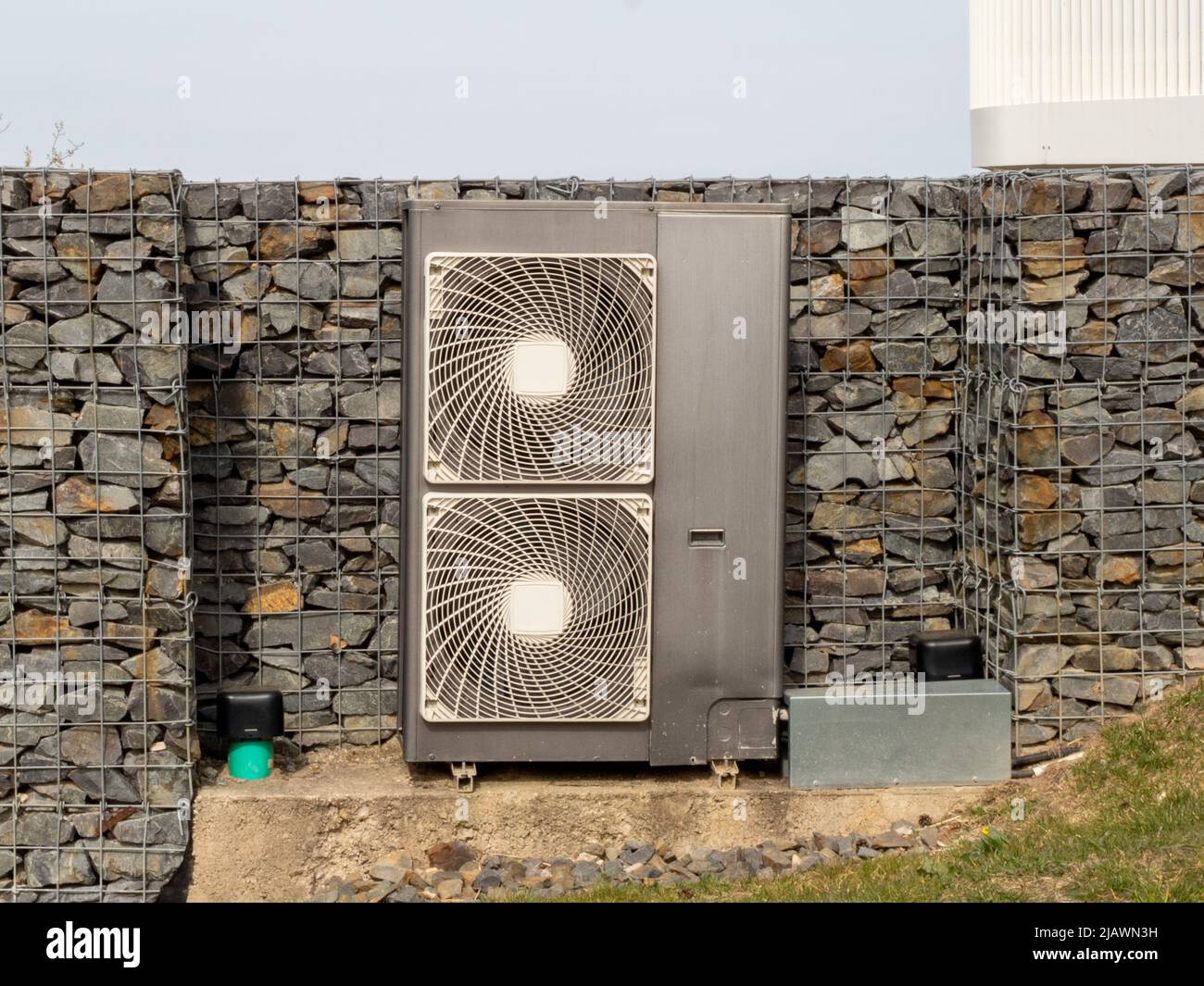 Air conditioning unit against a stone wall Stock Photo - Alamy