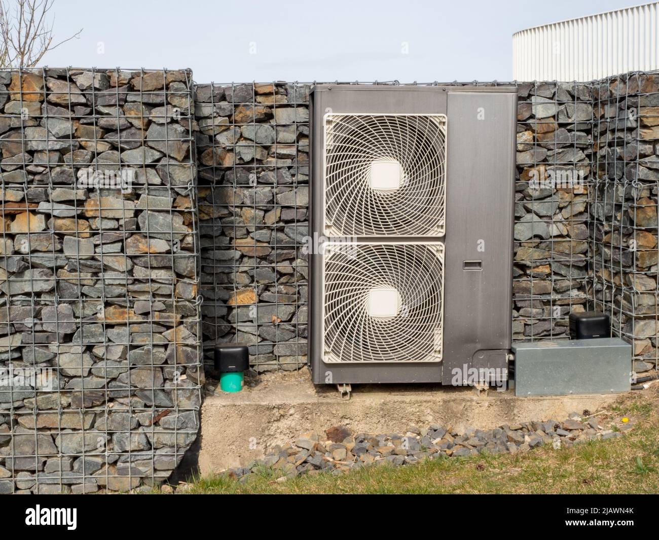 Air conditioning unit against a stone wall Stock Photo - Alamy