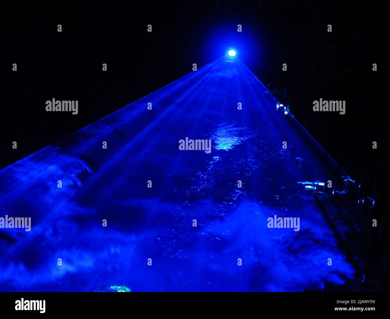 Blue neon glowing image on the water in night dark park. Image ...