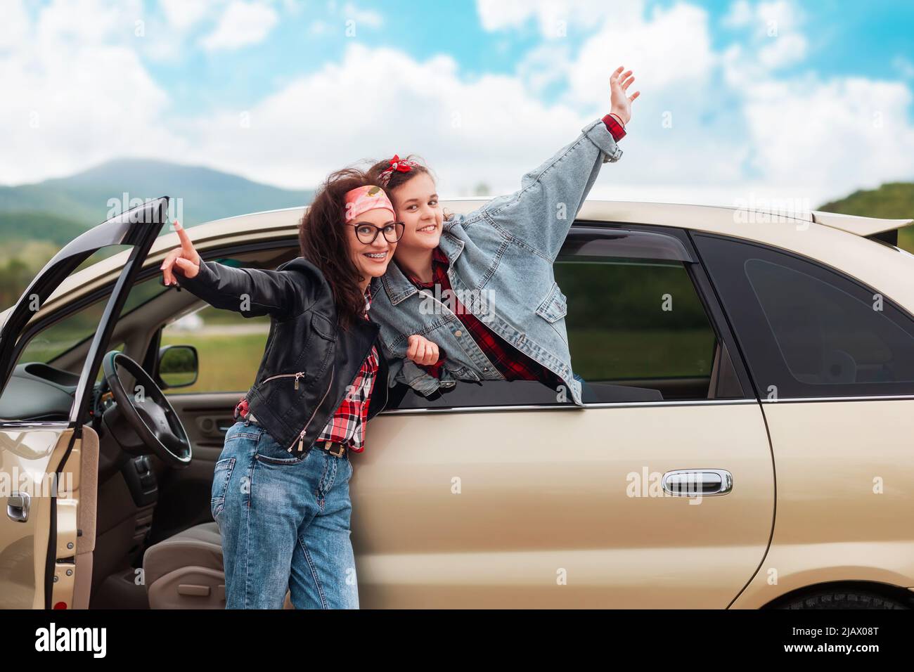Automobile's trip. Happy mother and daughter posing with a car. The ...