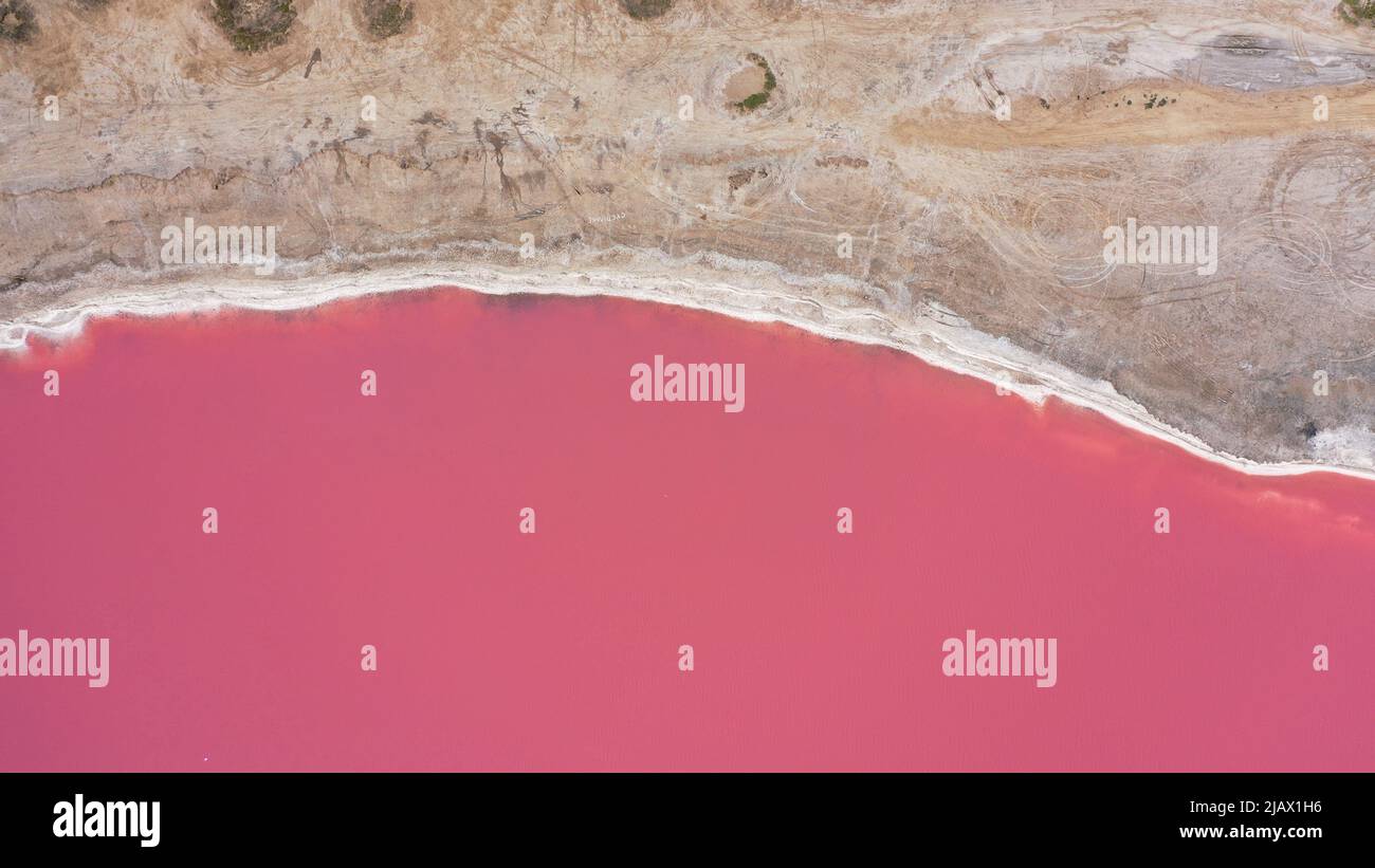 Flying over a pink salt lake. Salt production facilities saline ...