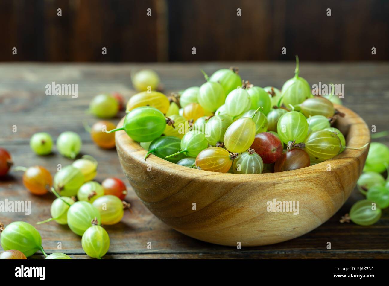 Ripe gooseberry in a wood plate, place for text, top view, summer ...