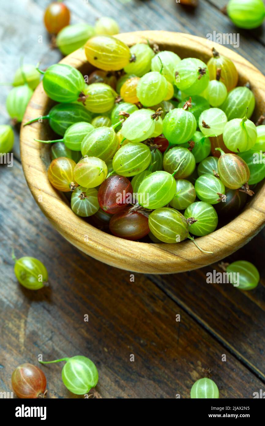 Ripe gooseberry in a wood plate, place for text, top view, summer ...