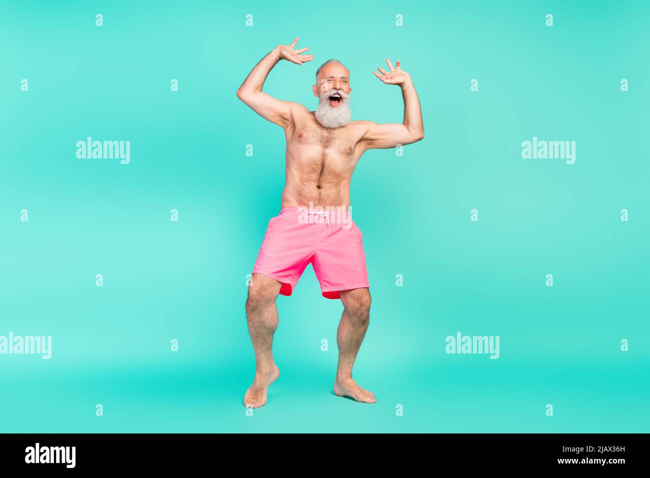 Photo of carefree old man dance beach party rejoice raise arms wear ...