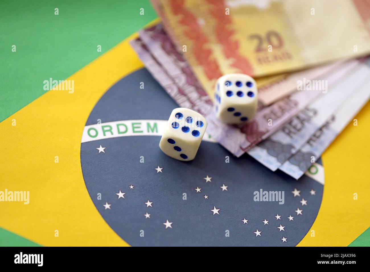 Small dice cubes with brazilian money bills on flag of Brasil Republic ...
