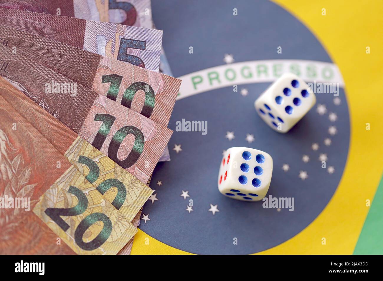 Small dice cubes with brazilian money bills on flag of Brasil Republic ...