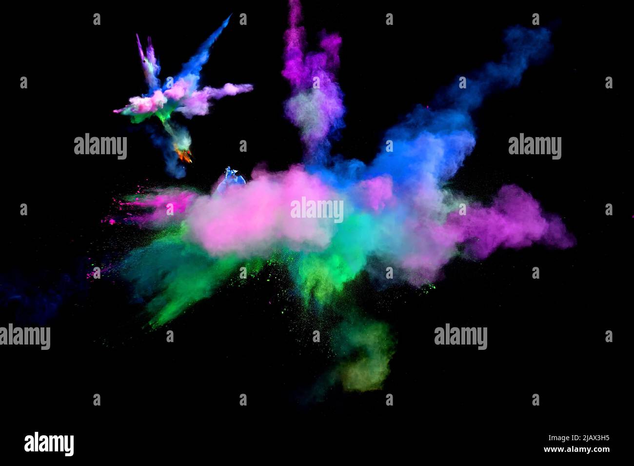 Various multicolored forms of powder paint explode in front of a black ...