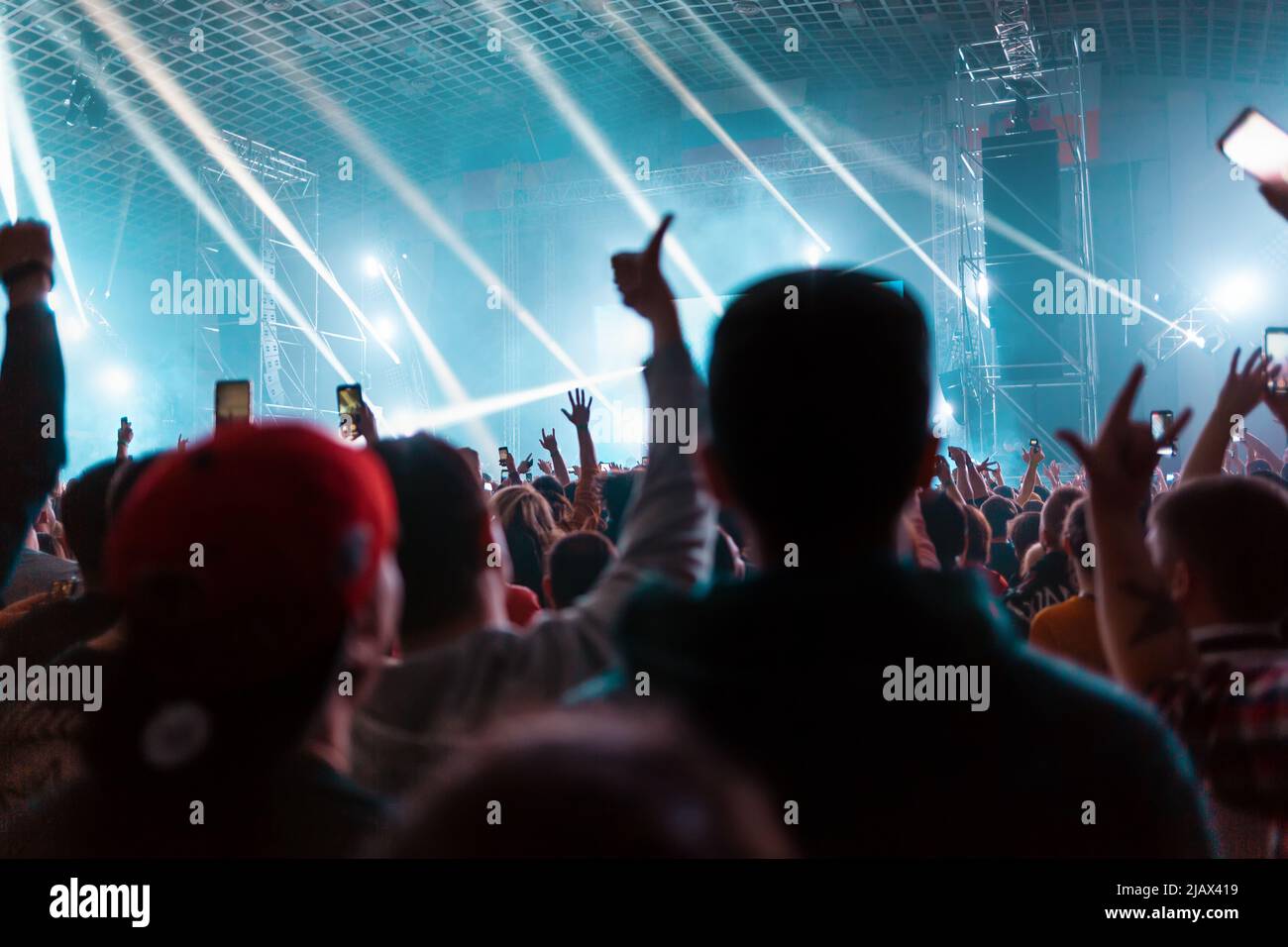 A crowd of people at the concert have fun and dance to the music at the ...