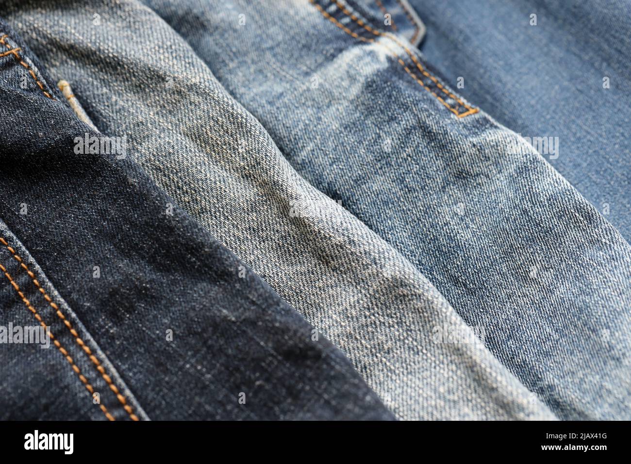Many jeans in stack in wardrobe room. Row of pants denim jeans in ...