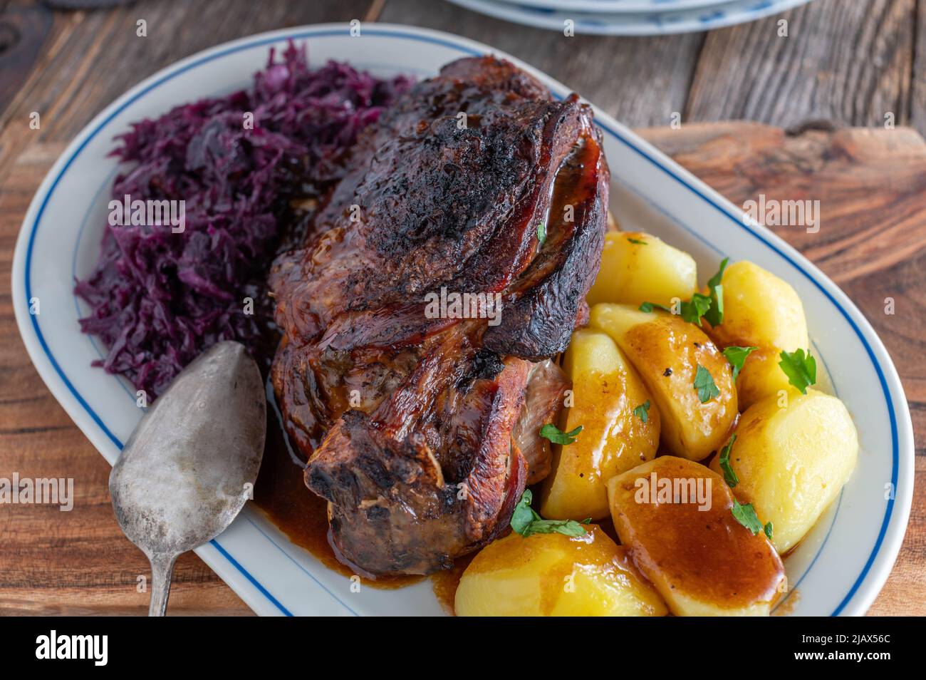 Roast dish with roasted turkey shank, red cabbage, boiled potatoes and ...