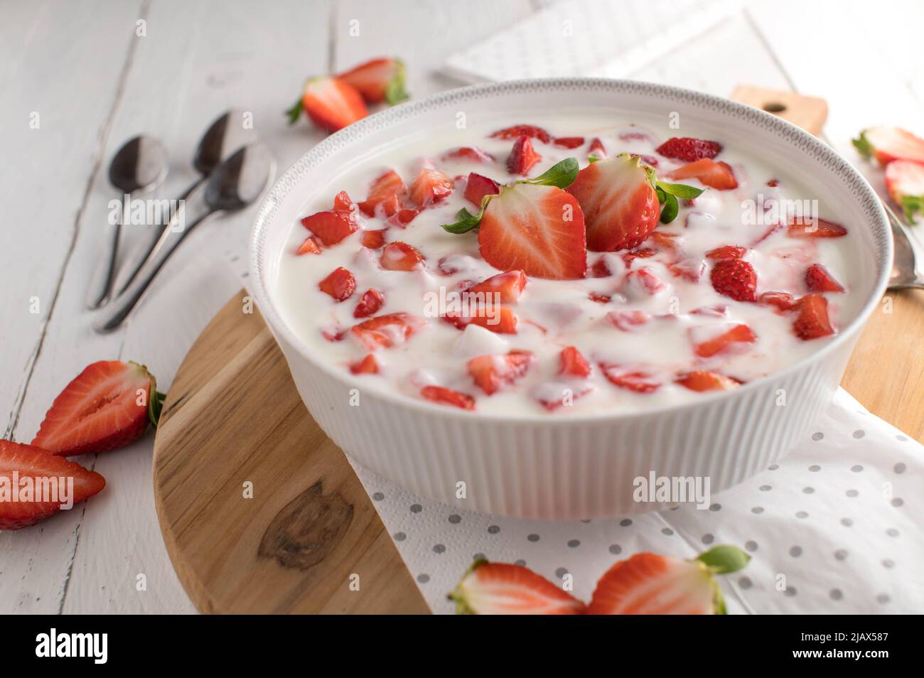 Chunky strawberry yogurt in a bowl on white kitchen table. Healthy ...