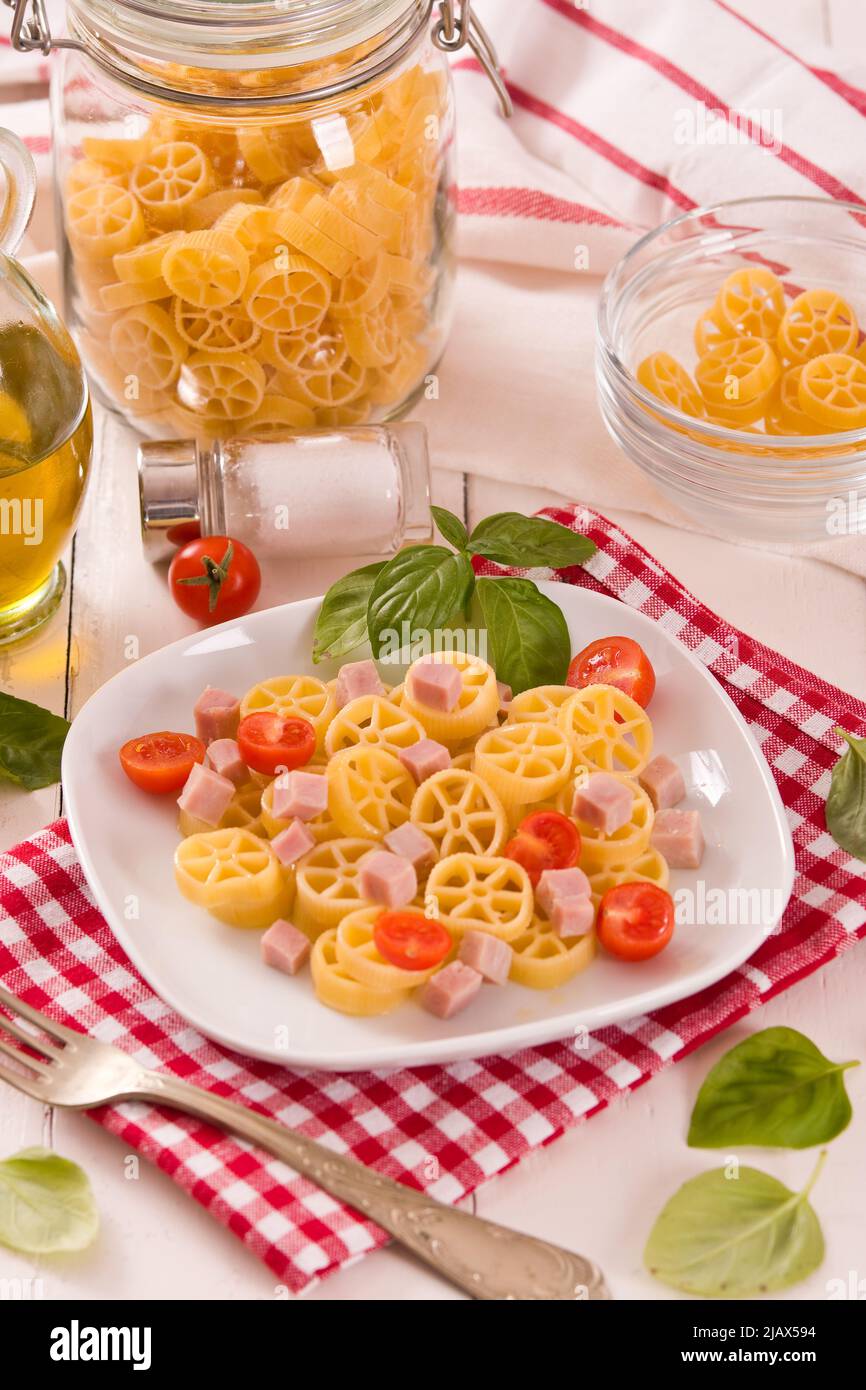 Ruote pasta with tomato and ham Stock Photo - Alamy