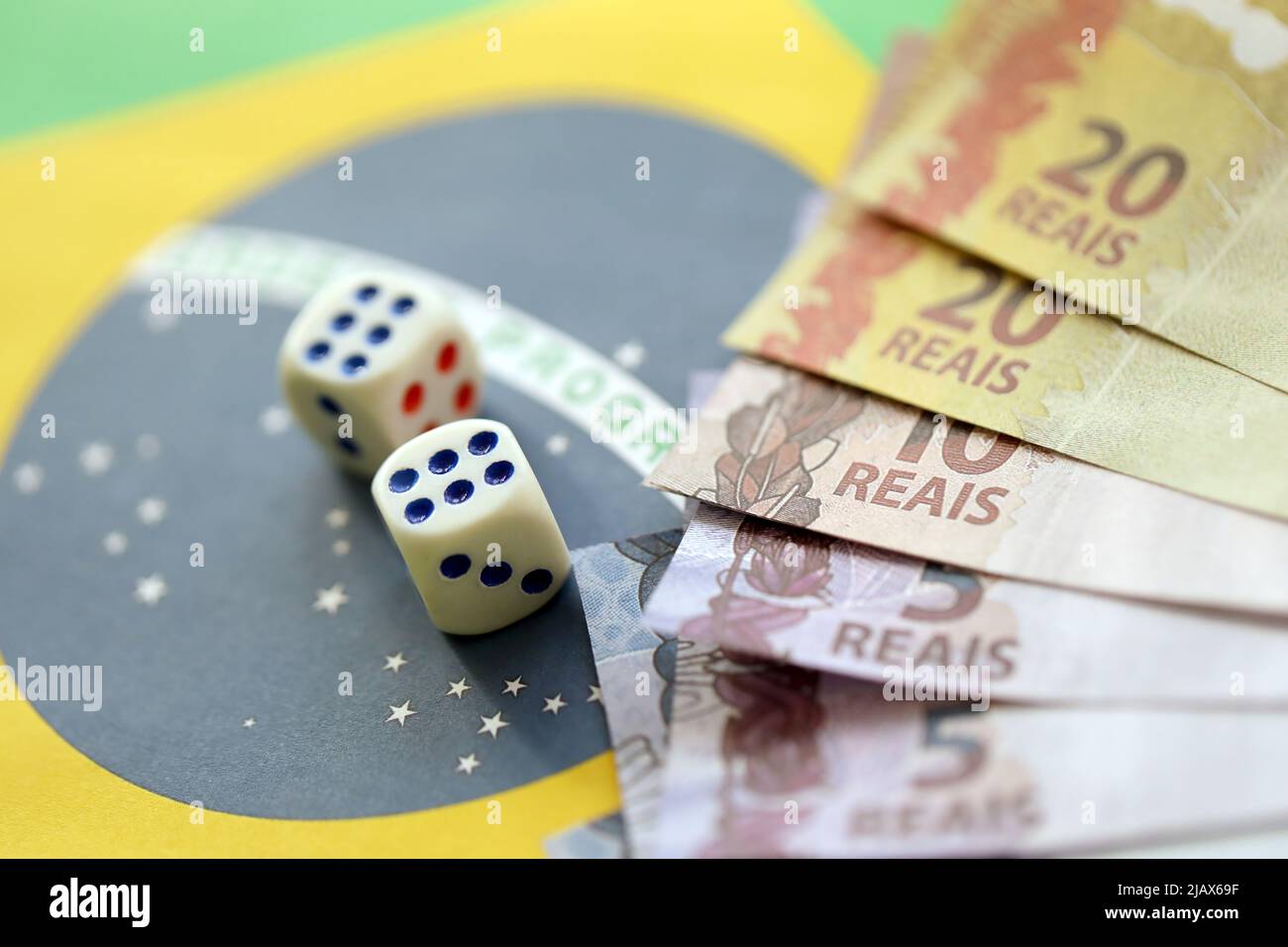 Small dice cubes with brazilian money bills on flag of Brasil Republic ...