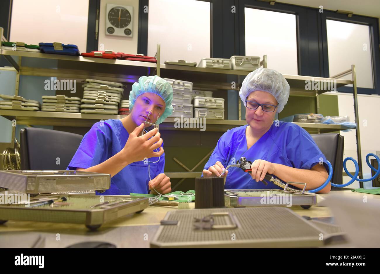 Two women are seen at their hospital workplace. They are dressed ...