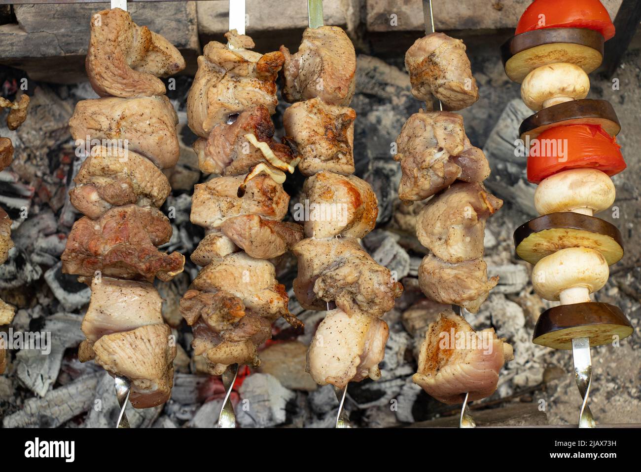 fried shish kebab on a fire in the forest on a picnic on skewers, roast ...