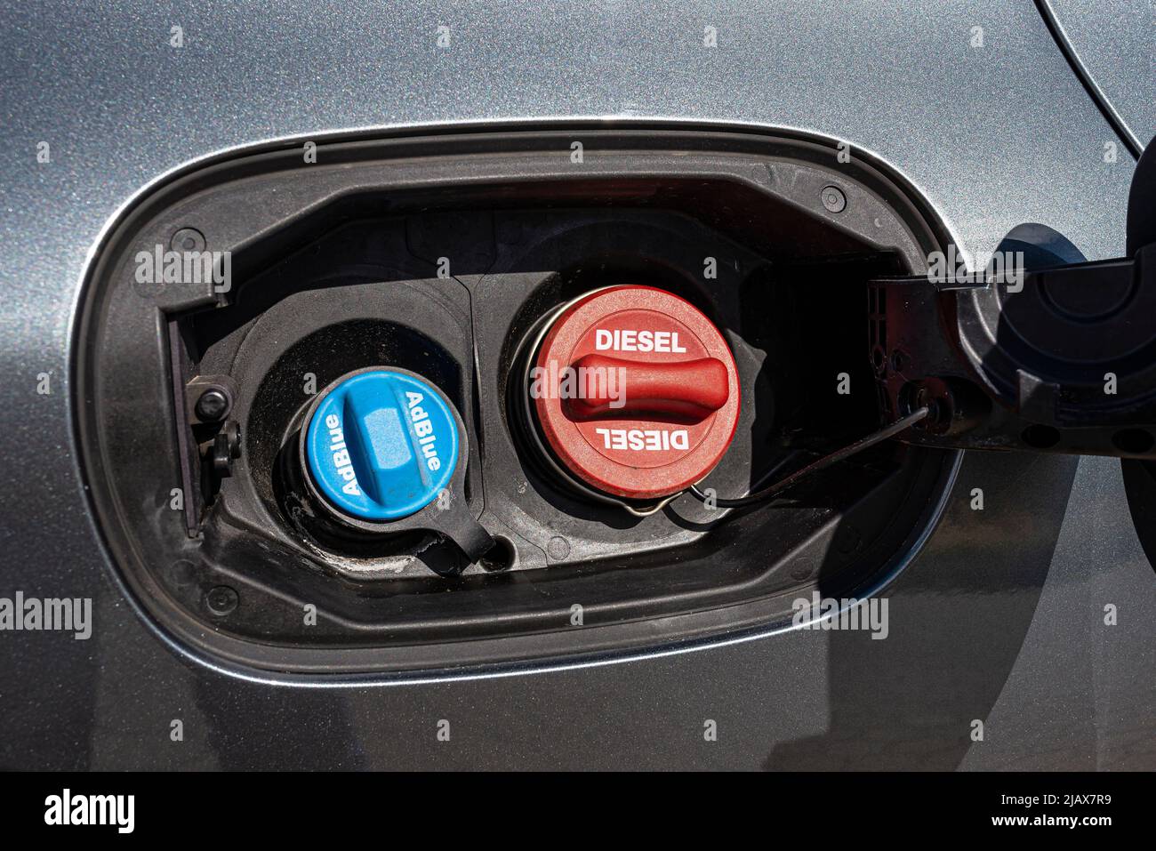 Fuel filler flap open with red diesel cap and blue adblue, the fuel ...