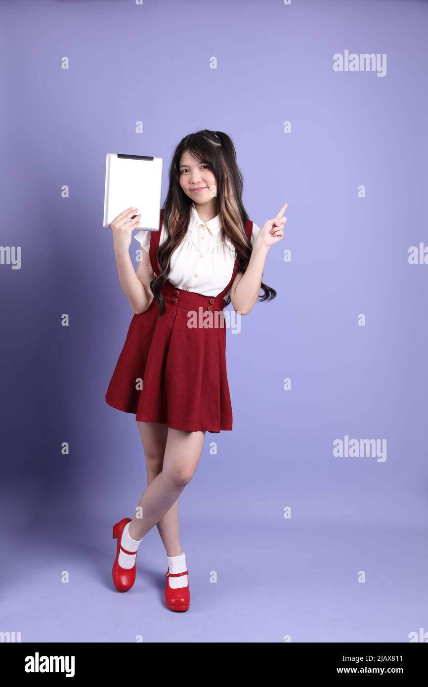 The cute young Asian woman with preppy dressed standing on the purple ...