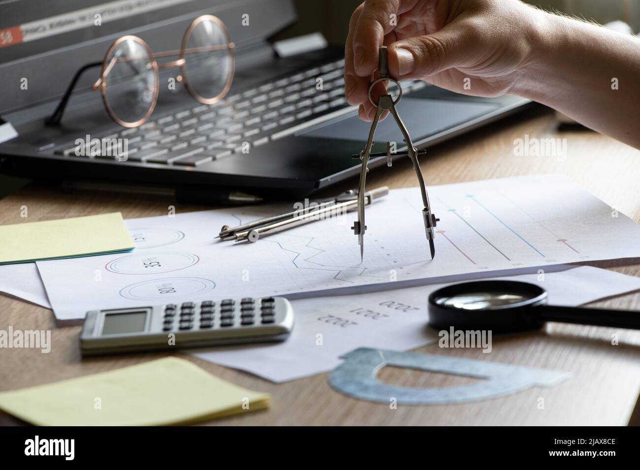 The girl sits at her desk and draws up graphs and histograms about ...