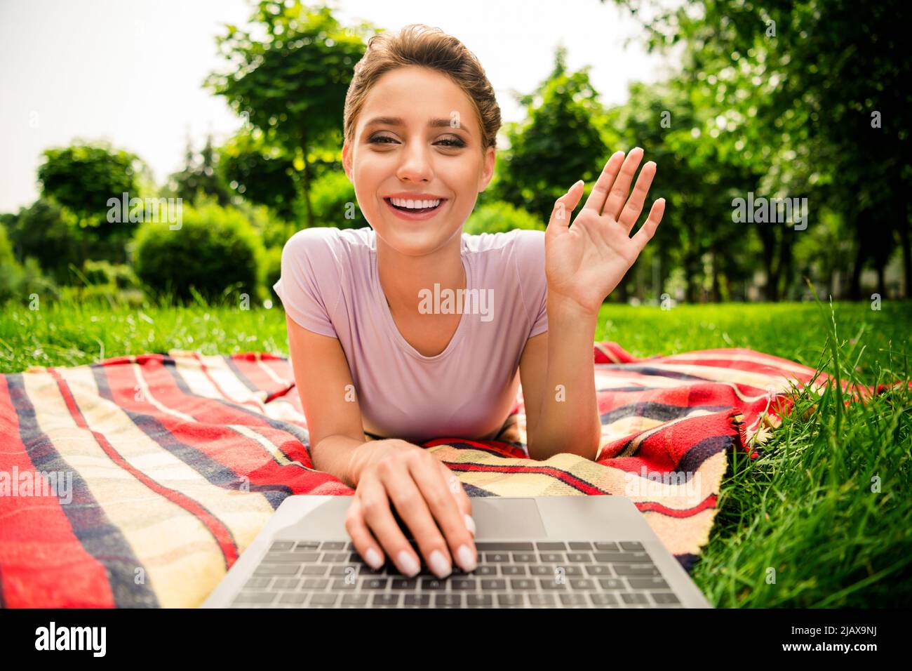 Portrait of attractive cheerful girl lying on veil calling friend video ...