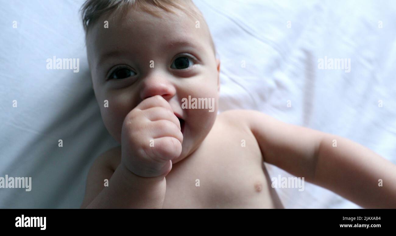Cute baby grimacing to camera, cute infant toddler lying in bed Stock ...