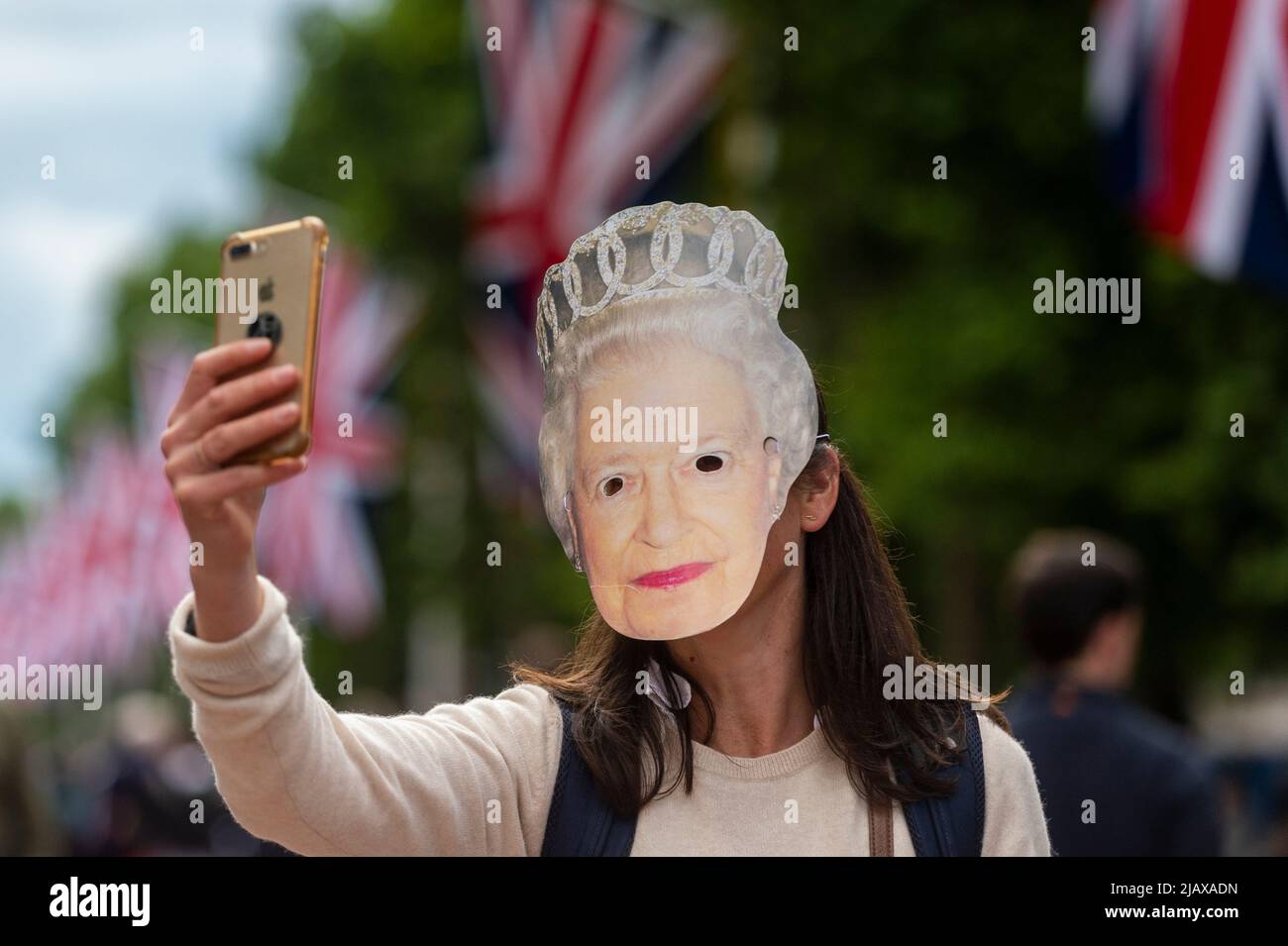 London, UK. 1 June 2022. A Royal fan wearing a mask of The Queen in The ...
