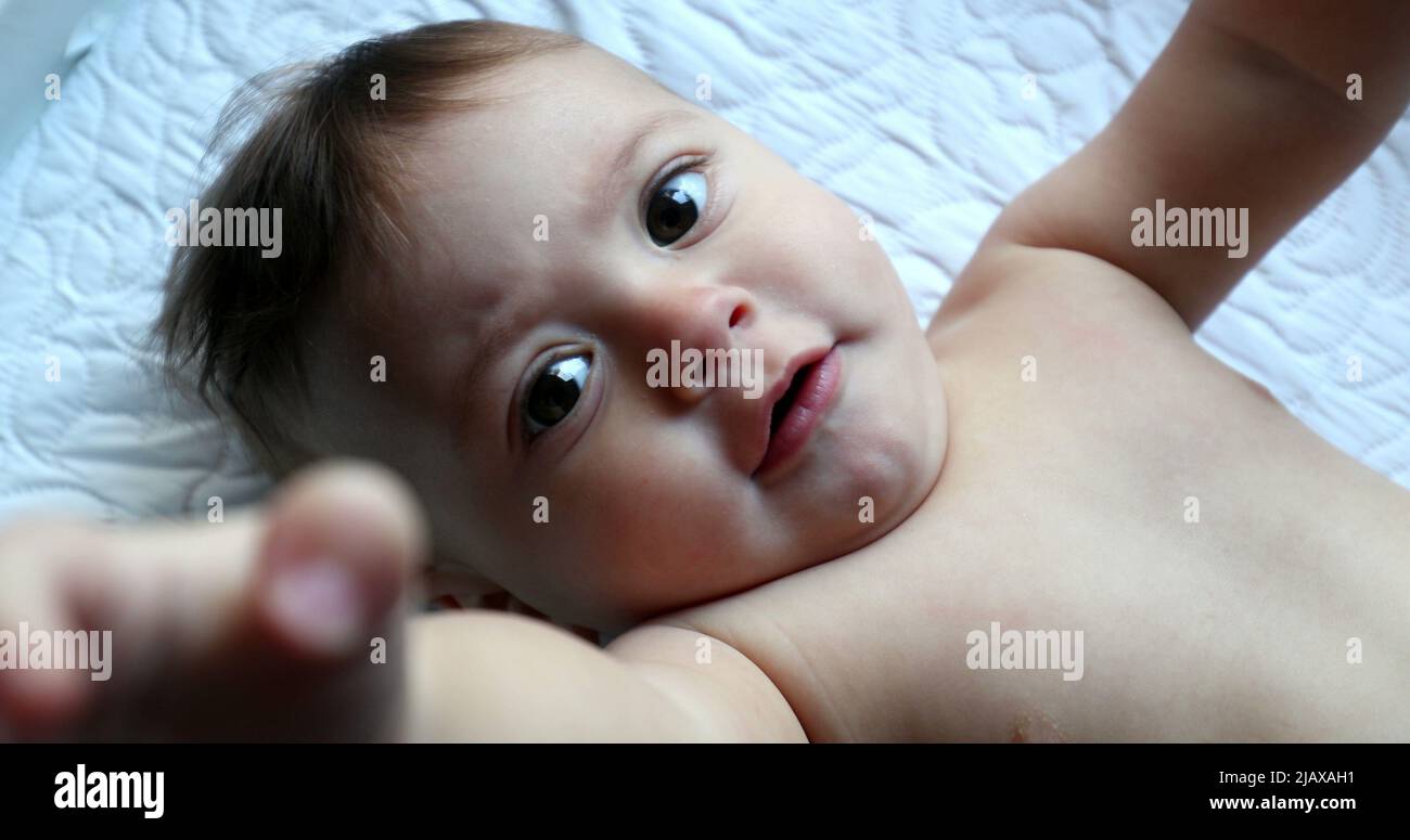 Cute baby infant reaching out hand to touch camera, adorable toddler ...