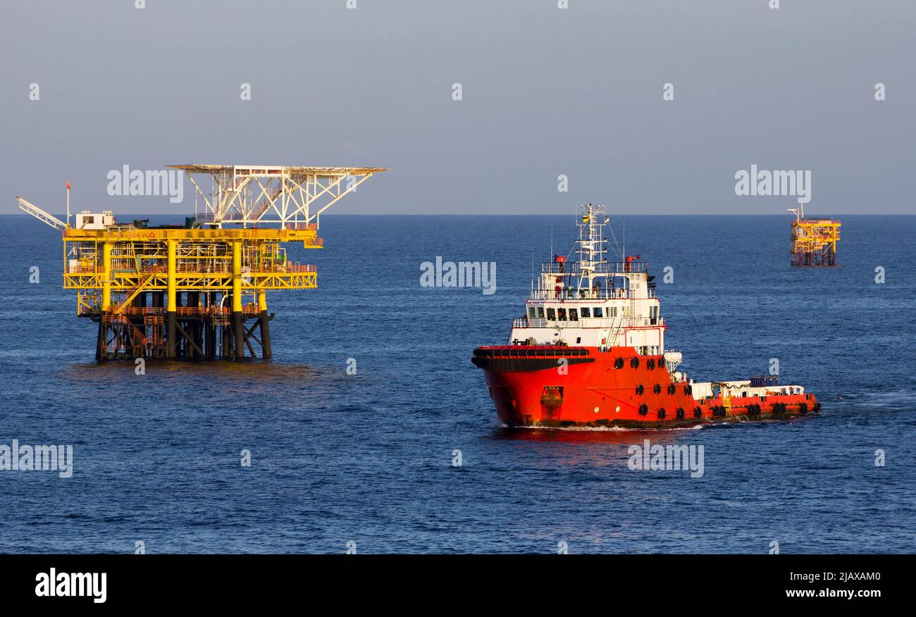 Oil rigs with supply boat boat for transporting people or materials to ...