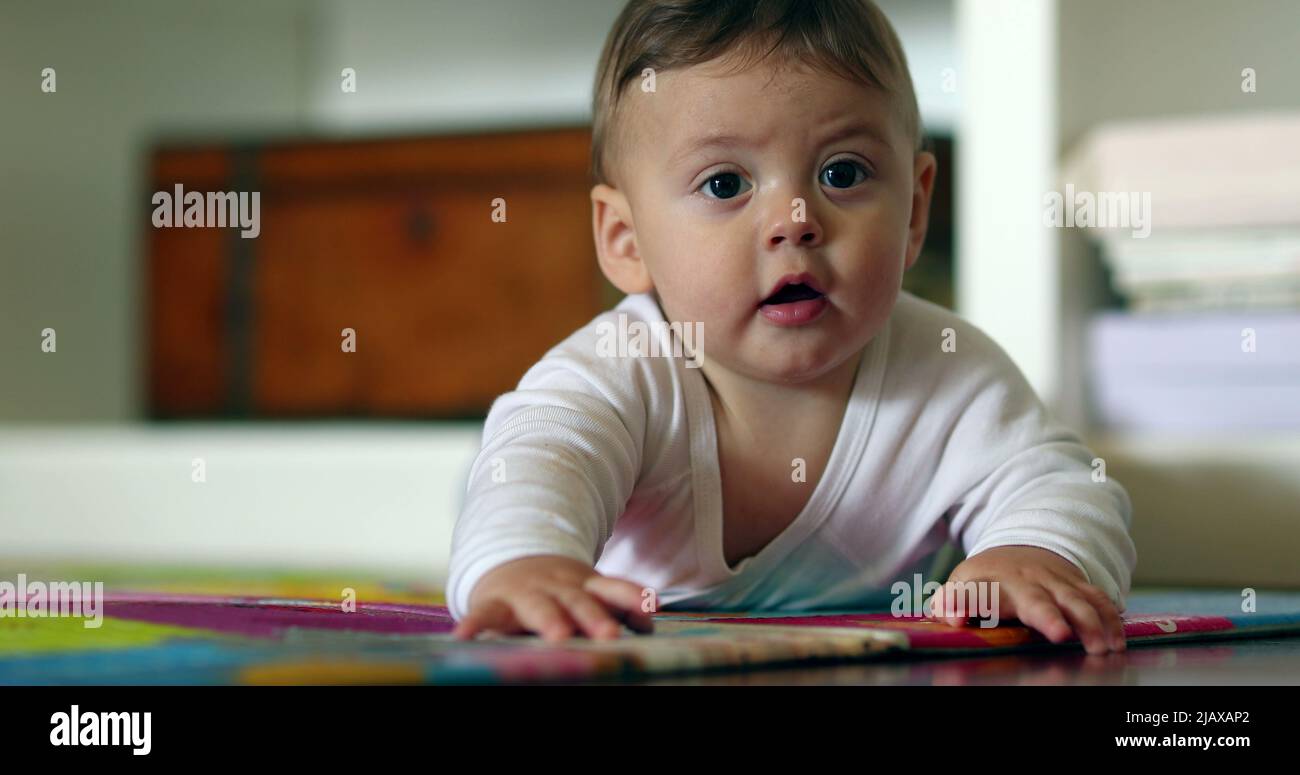 Cute baby lying on floor touching play carpet Stock Photo - Alamy