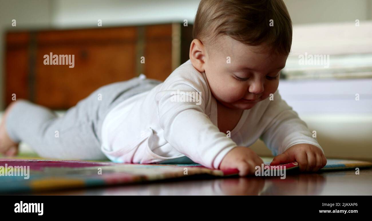 Cute baby lying on floor touching play carpet exploring and discovering ...