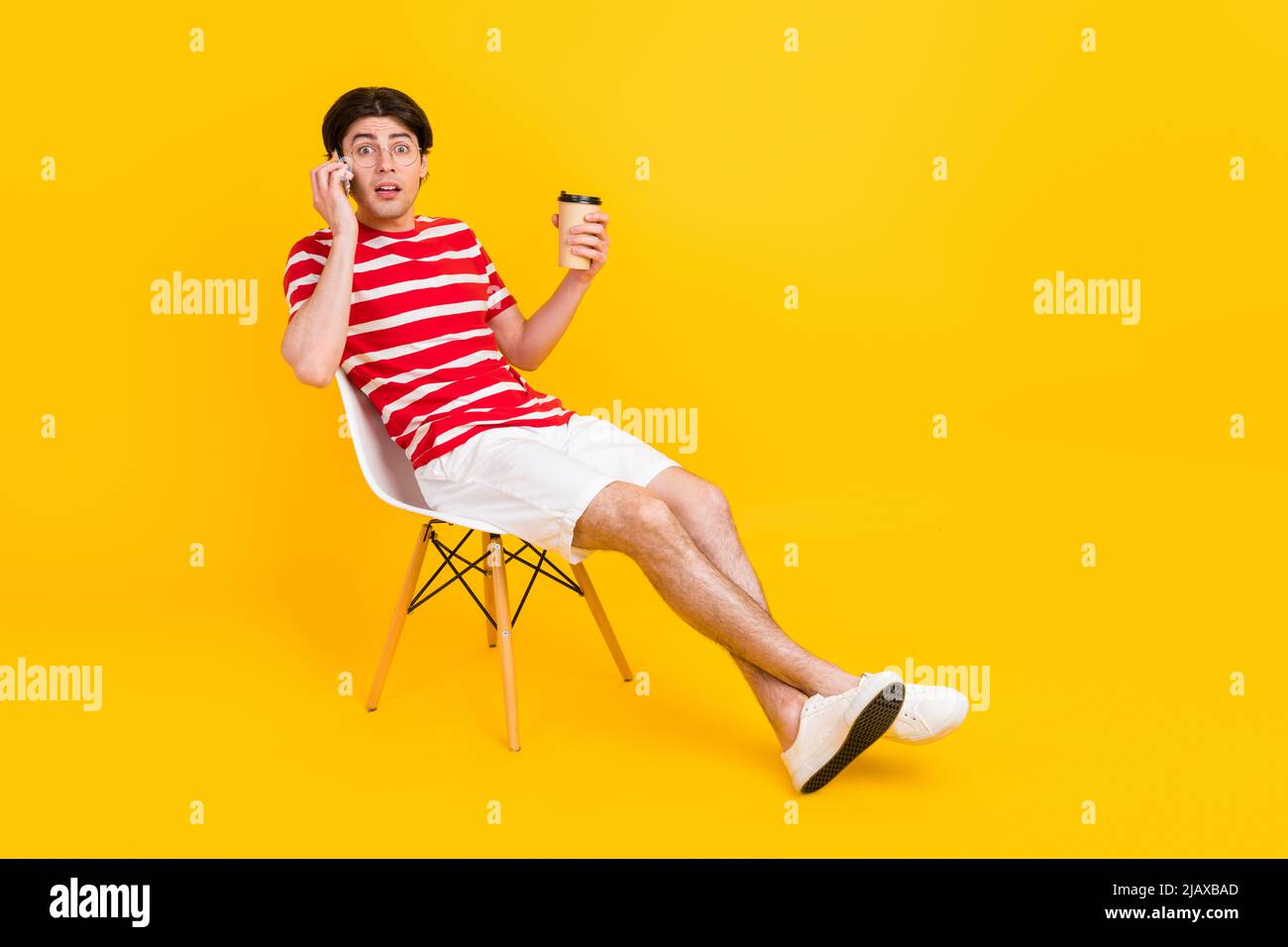 Photo of shocked scared man wear t-shirt spectacles sitting talking ...