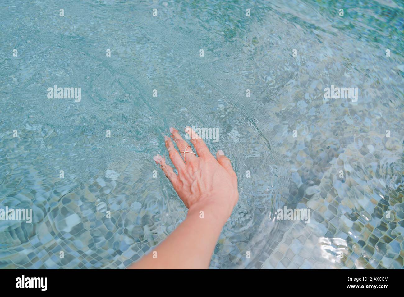 A woman's hand in the pool close-up Stock Photo - Alamy