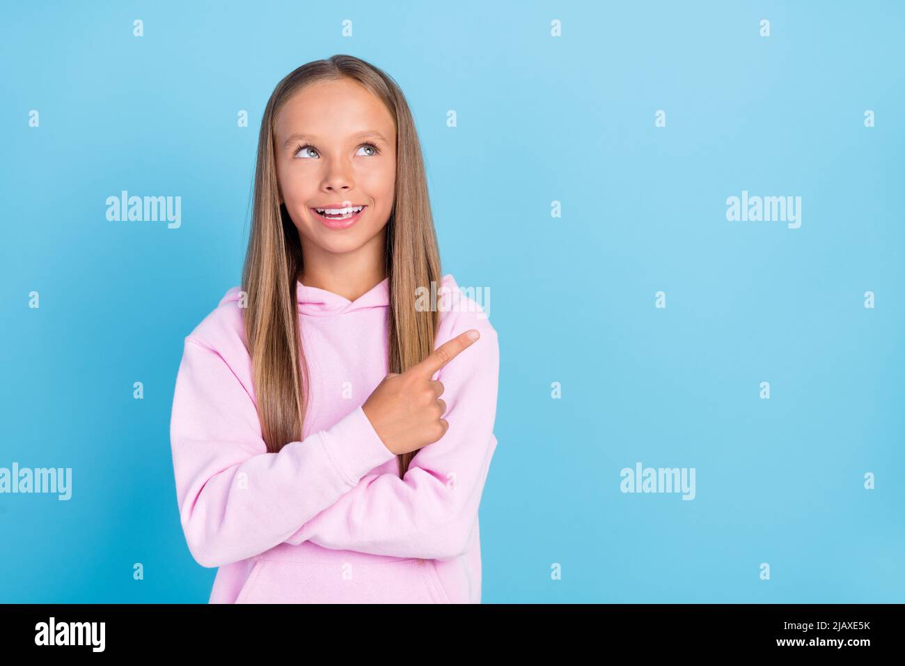 Photo of dreamy joyful happy little girl point finger empty space look ...