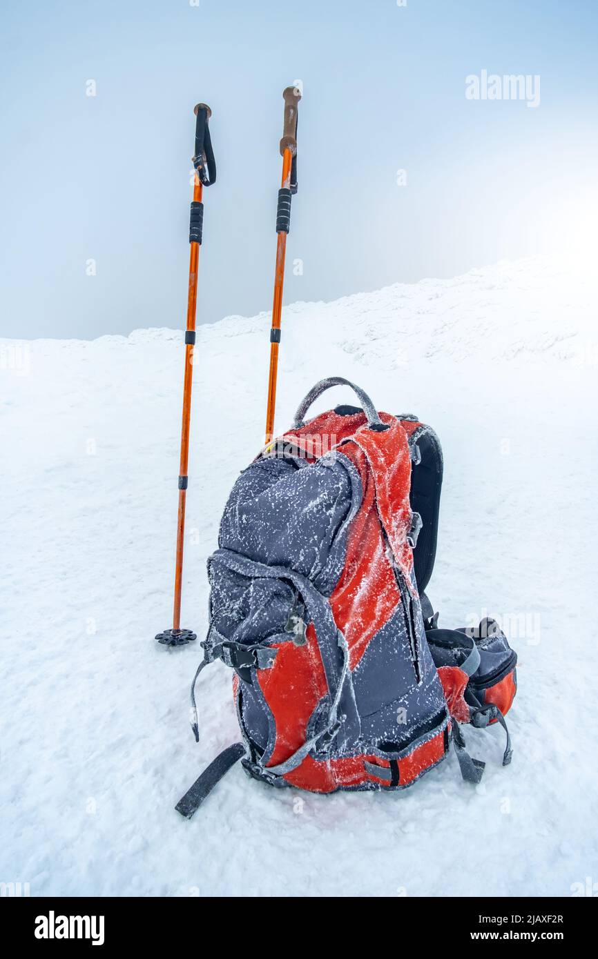 Trekking sticks and backpack on snow Stock Photo - Alamy