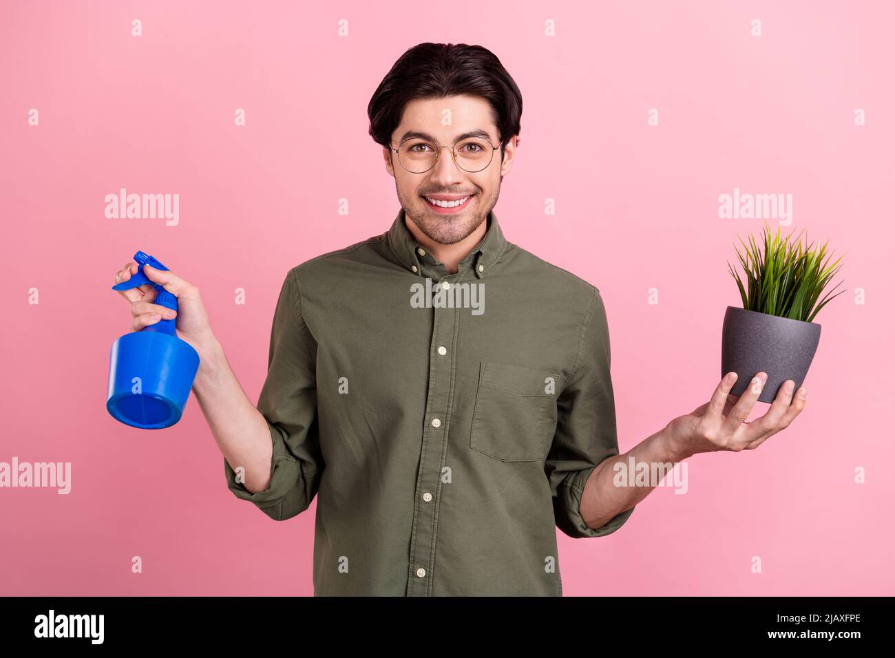 Photo of young happy positive cheerful man hold hands plant pulverizer ...