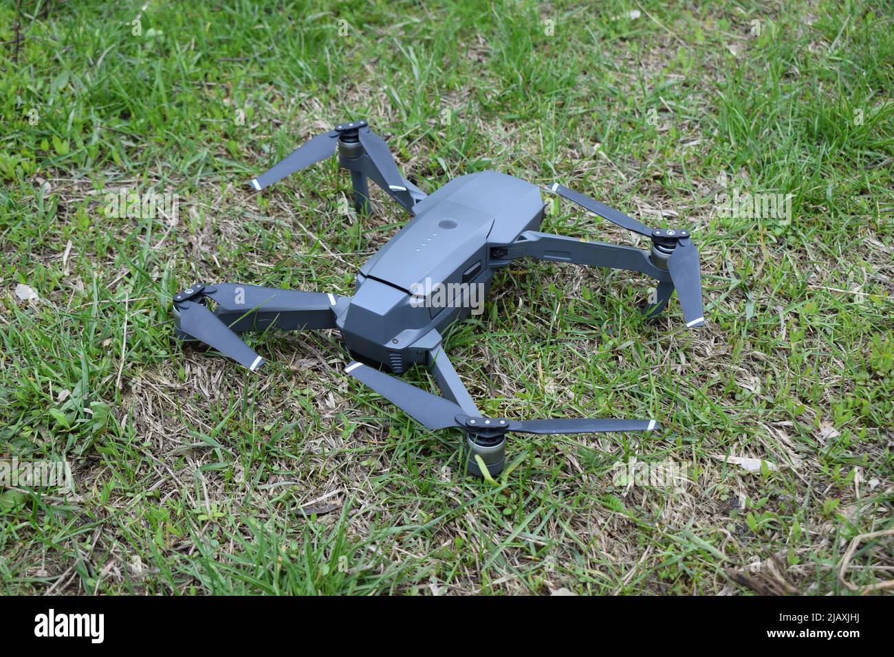 Mini drone unfolded on a grass before take-off. Small drone flies in ...