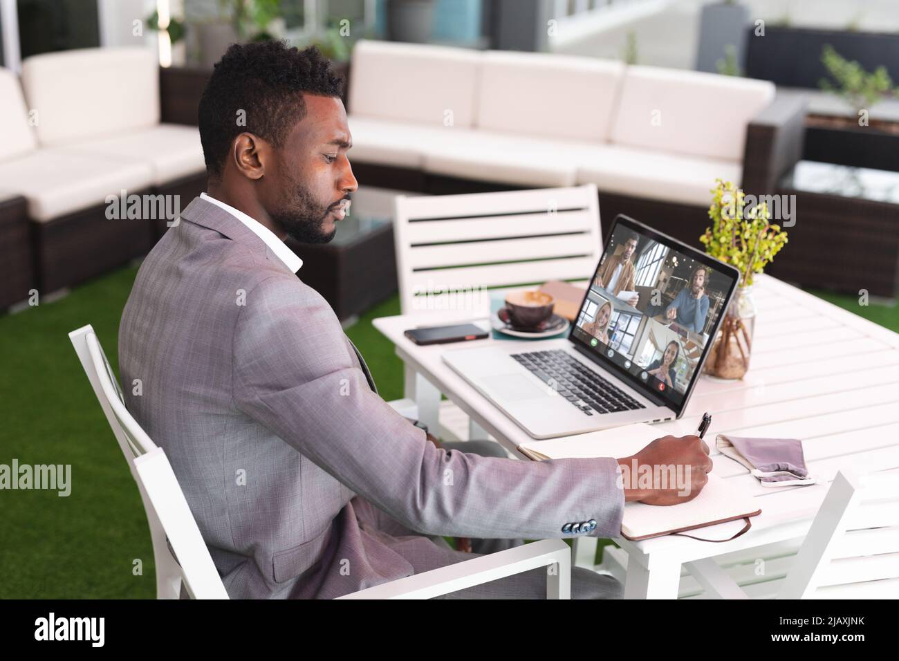 African american young businessman using laptop during online meet with multiracial colleagues ...