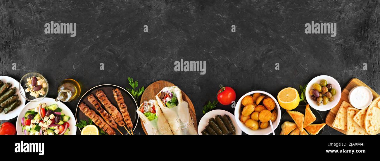 Greek food bottom border, top view on a dark banner background ...