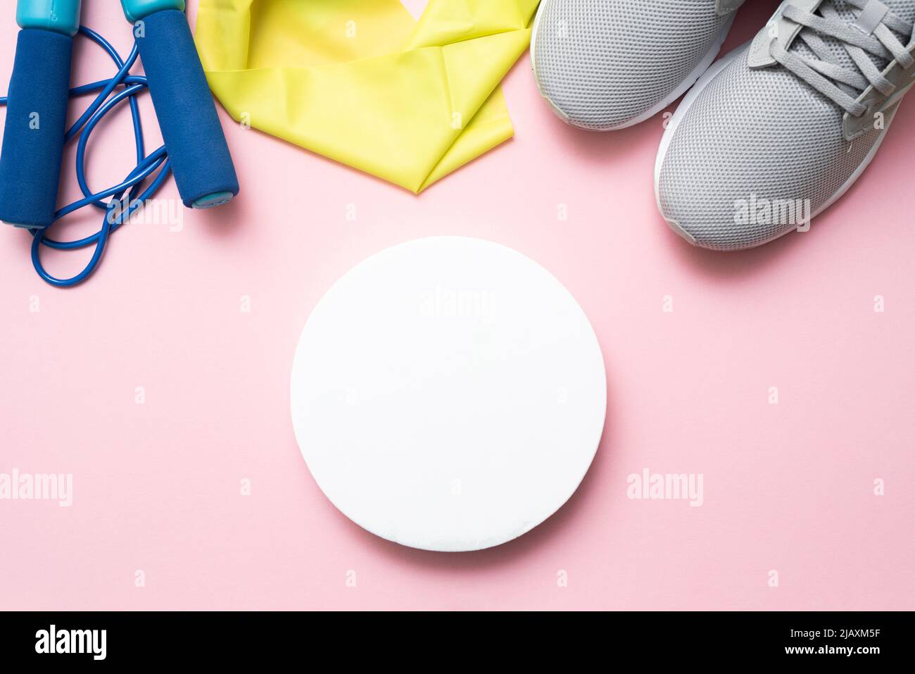 Exercise equipment on a pink background with a round mock up. Copy ...
