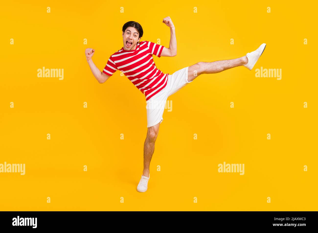 Full body photo of happy positive amazed young man hold hands flex leg ...