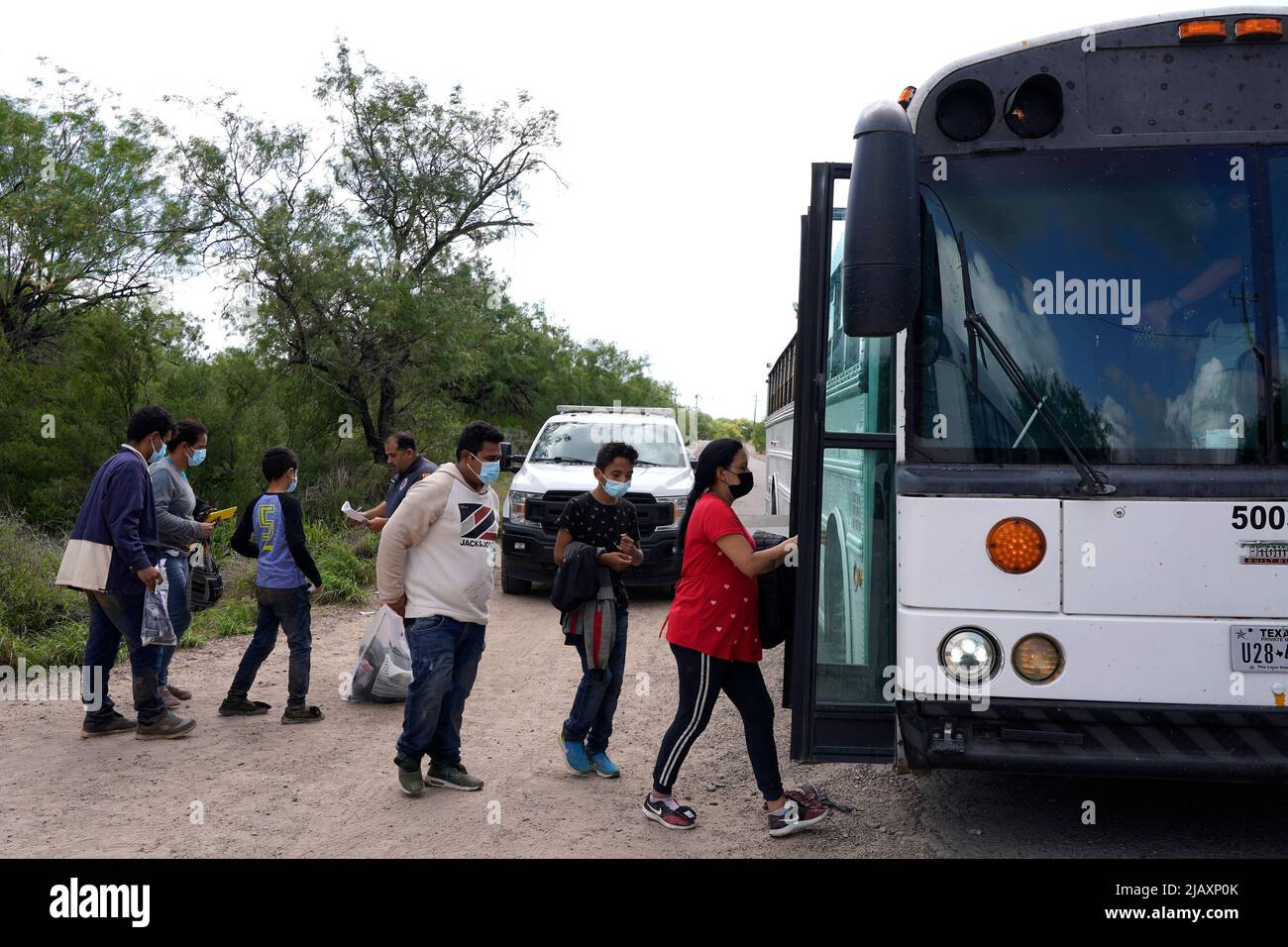 Migrants bord a US Border Patrol bus for the detention center on the ...