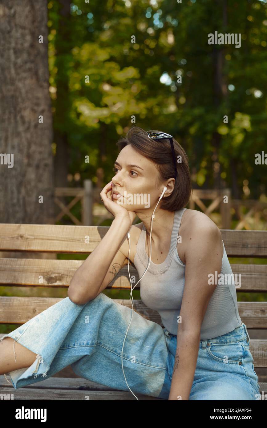 Portrait of a young american woman listening to music on cell phone ...
