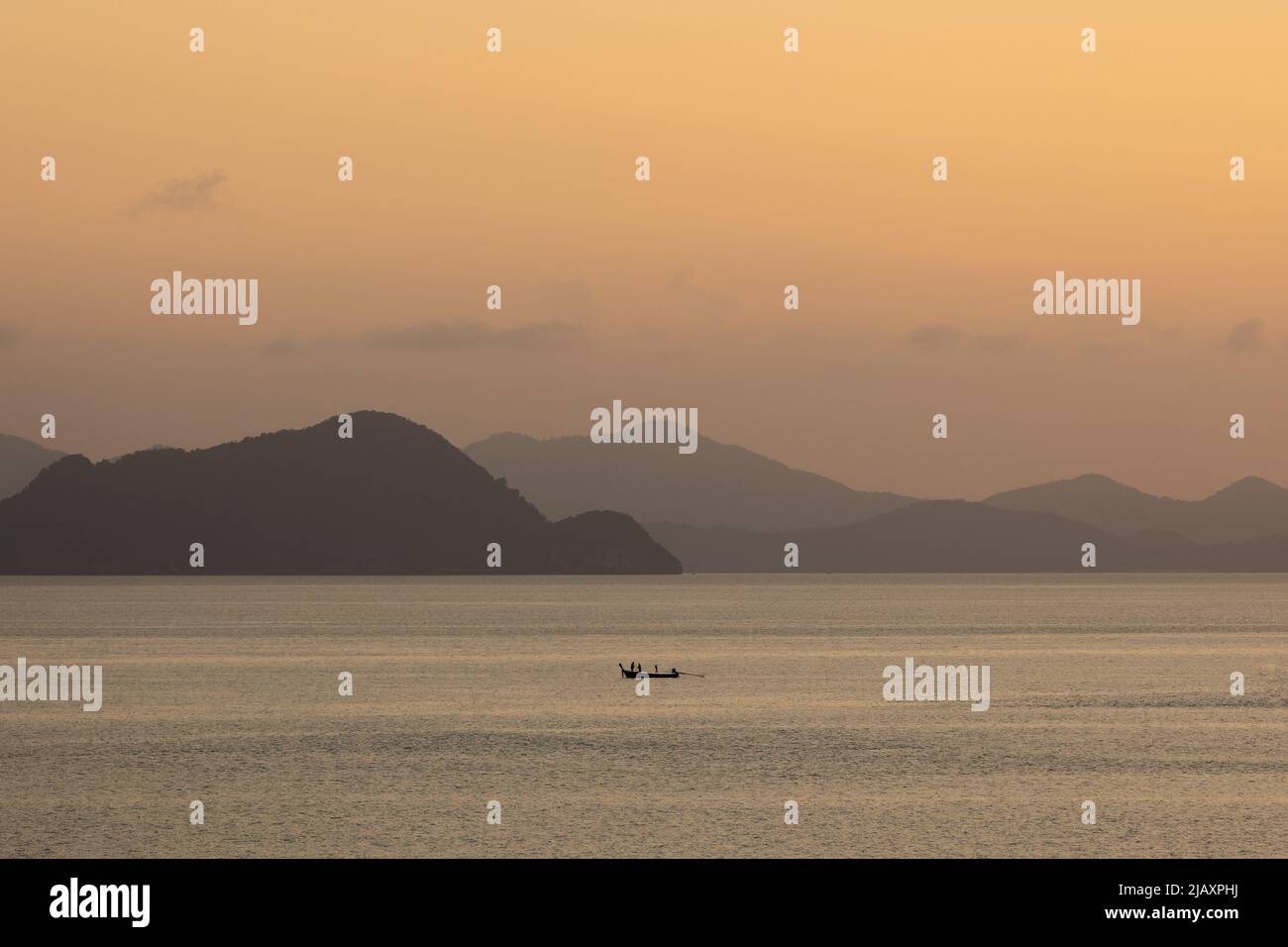 Isolated boat in front of layers of mountains at sunset Stock Photo - Alamy
