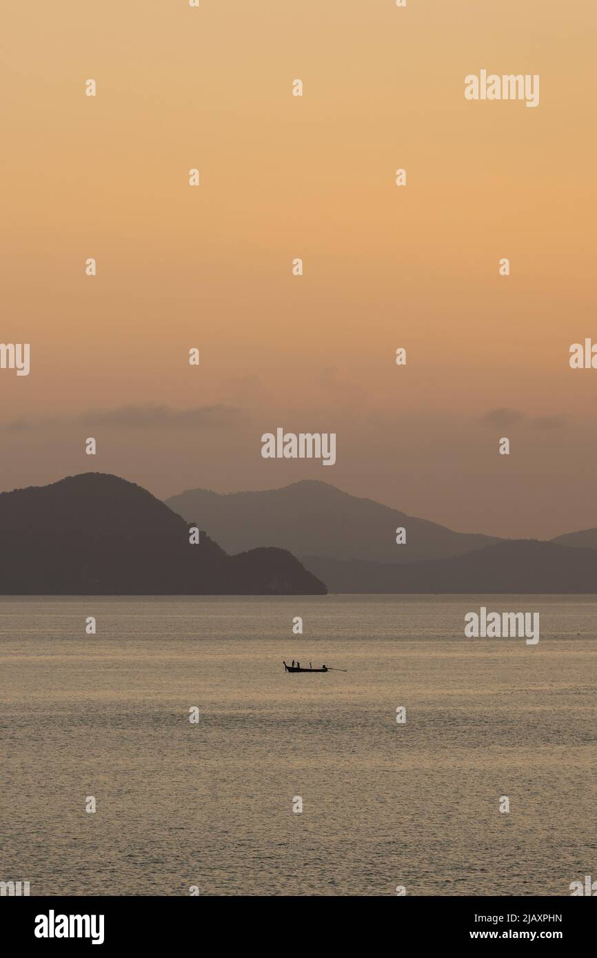 Isolated boat in front of layers of mountains at sunset Stock Photo - Alamy